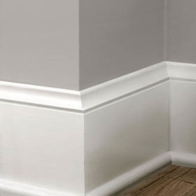 White Baseboard Trim with Dark Wood Door - Iowa Remodels